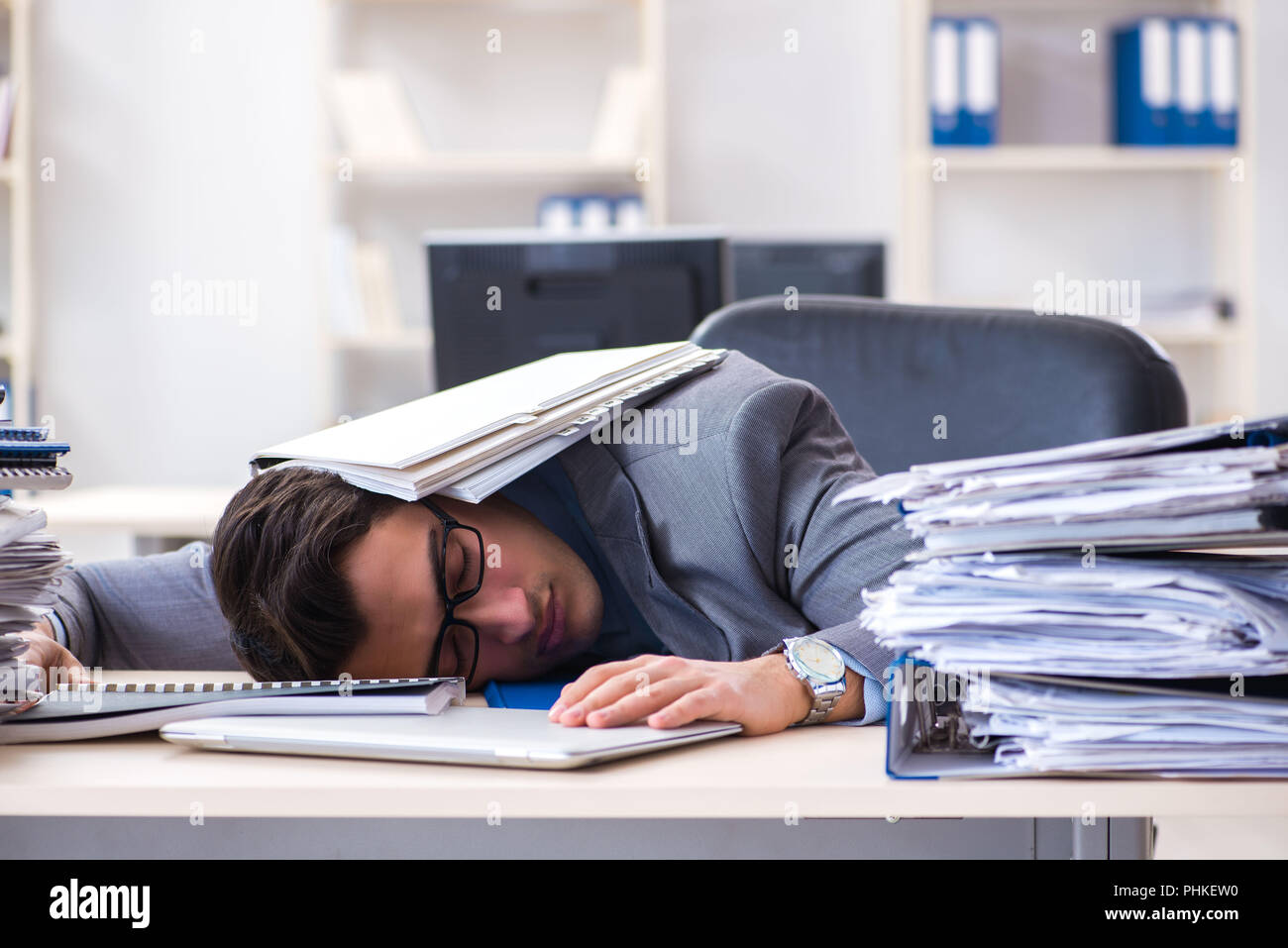 Overloaded with work employee under paperwork burden Stock Photo - Alamy