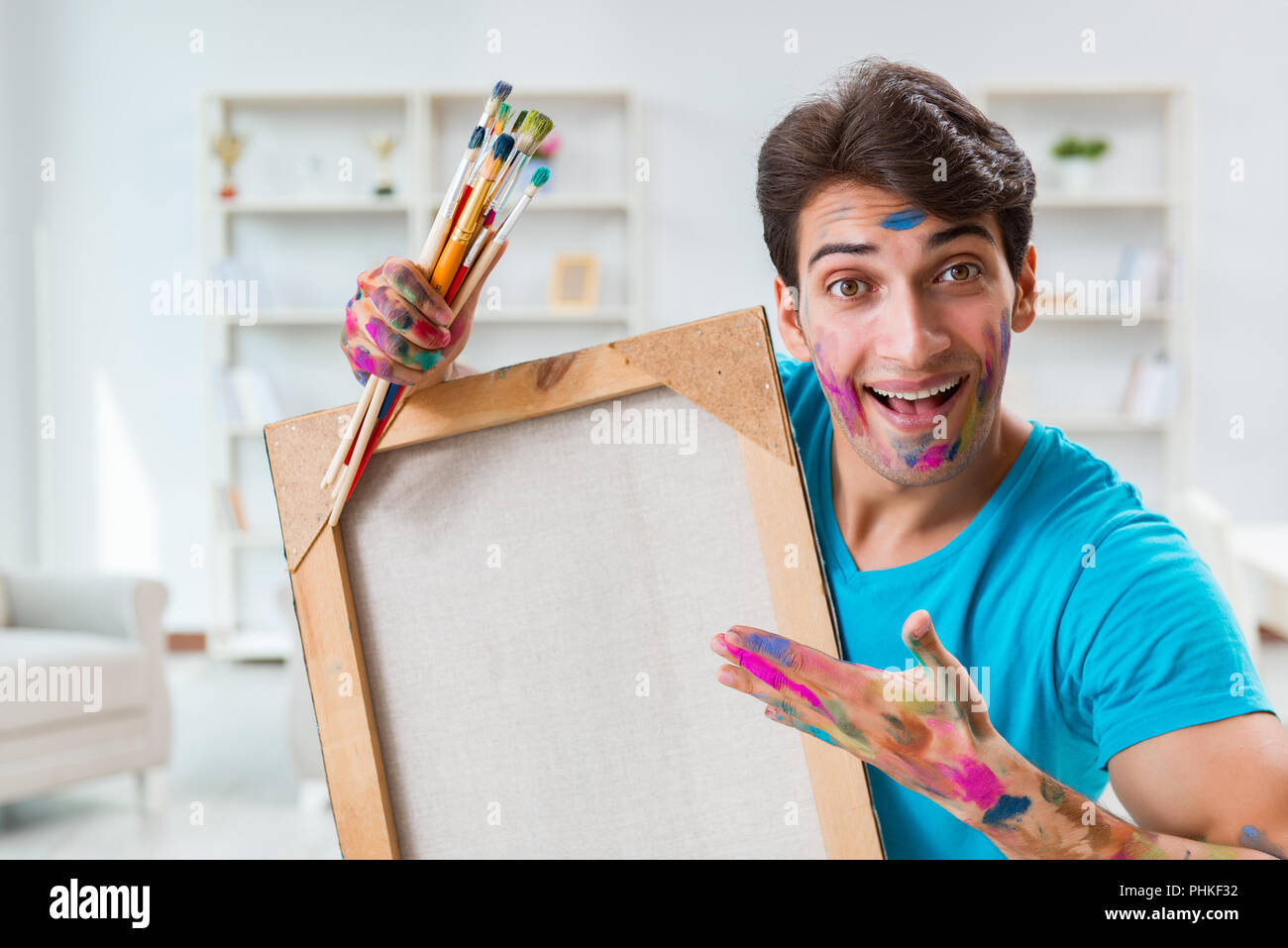 Young funny artist working on new painting in his studio Stock Photo ...