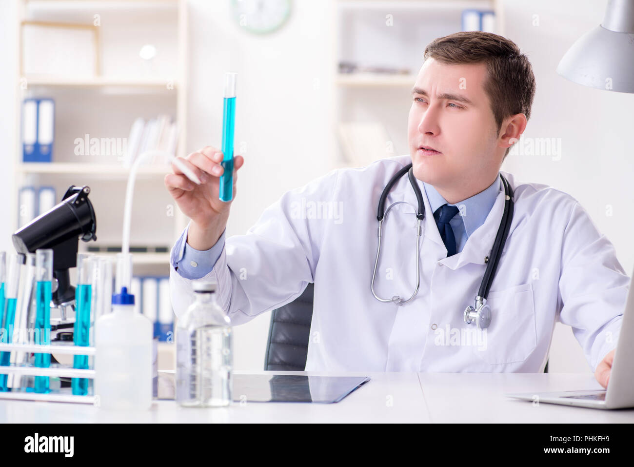 Male doctor looking at lab results in hospital Stock Photo - Alamy