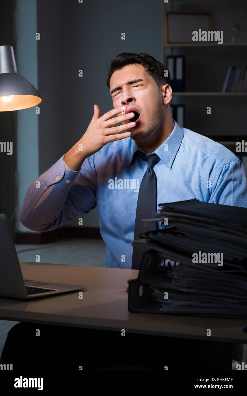 Employee working late at night at important report Stock Photo - Alamy