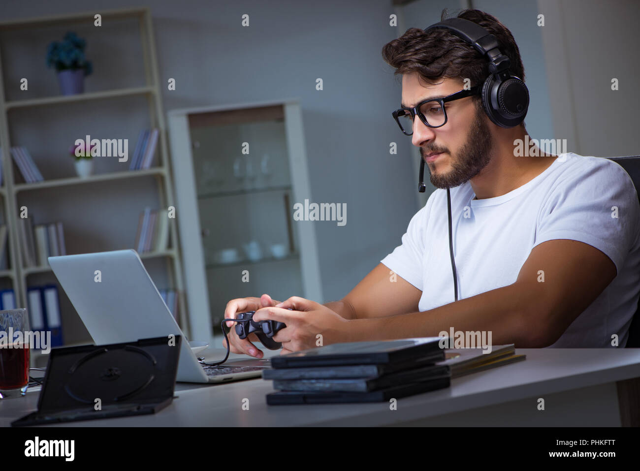 Young man playing games long hours late in the office Stock Photo - Alamy