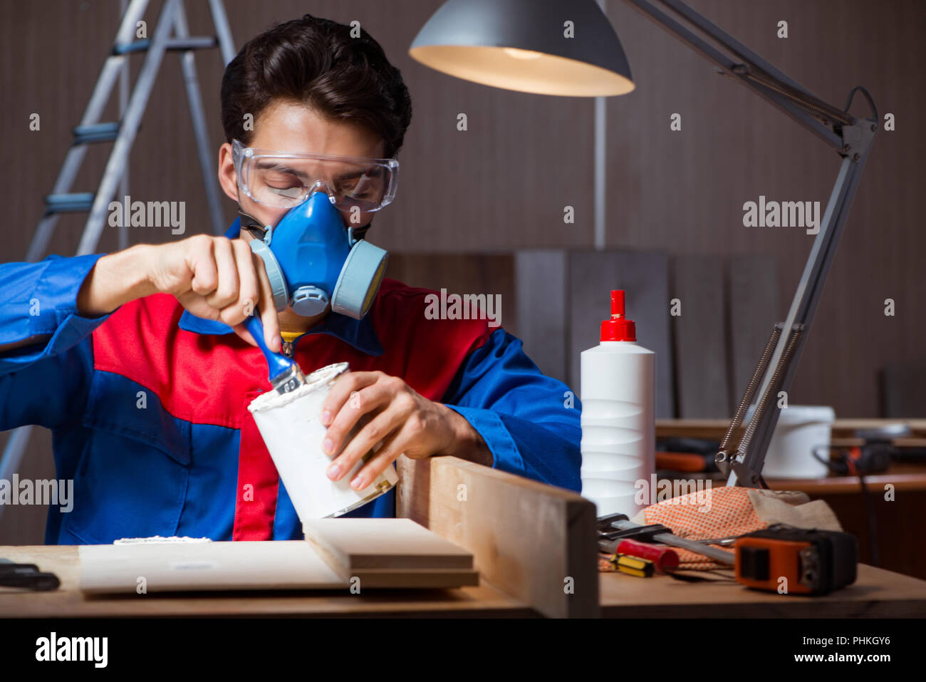 Young man gluing wood pieces together in DIY concept Stock Photo - Alamy