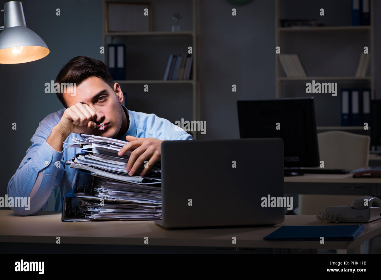 Employee working late at night at important report Stock Photo - Alamy