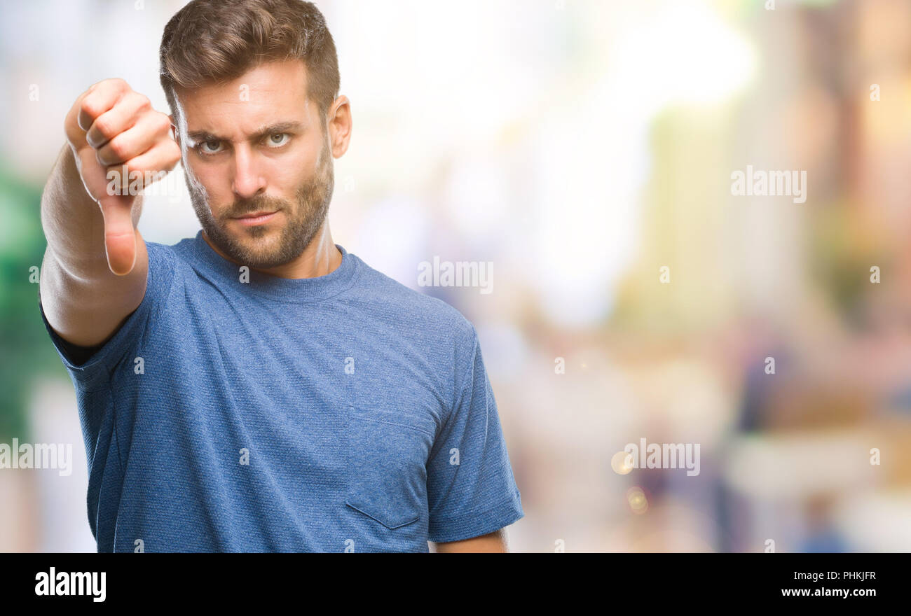 Young handsome man over isolated background looking unhappy and angry ...
