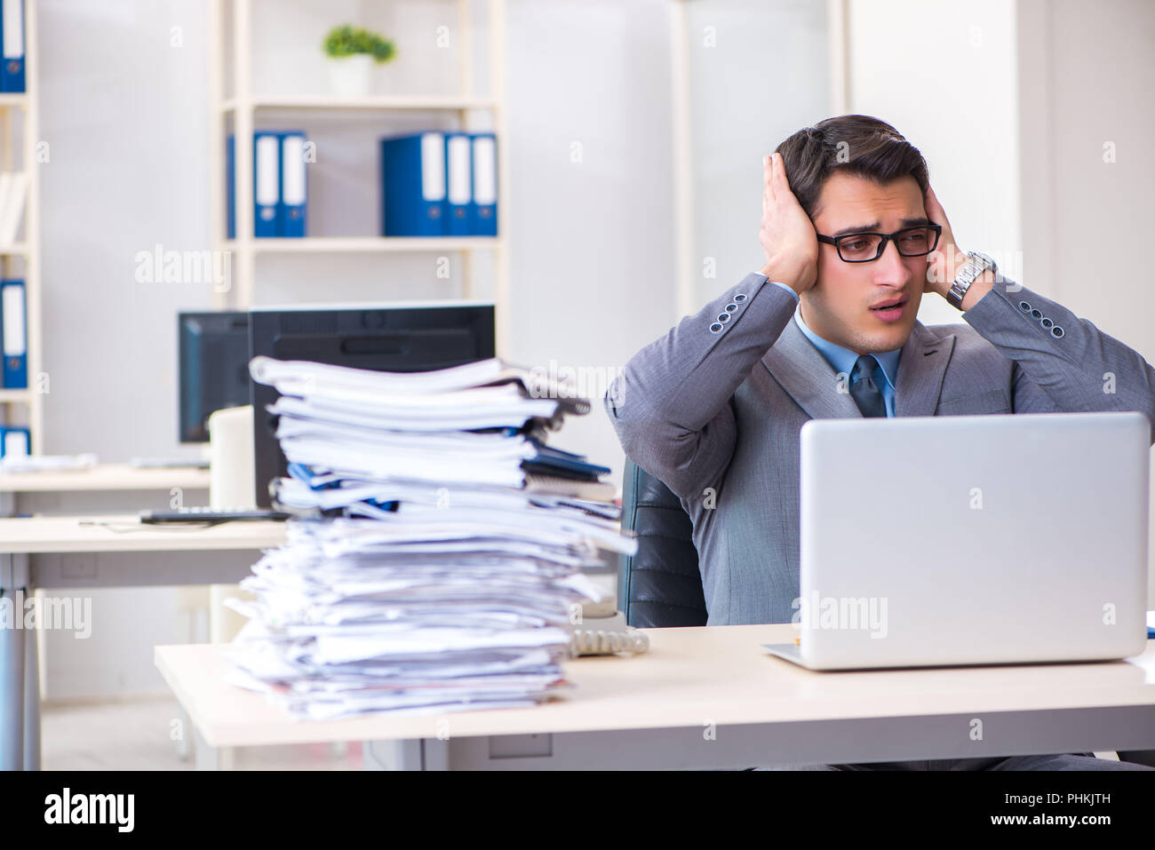 Overloaded with work employee under paperwork burden Stock Photo - Alamy