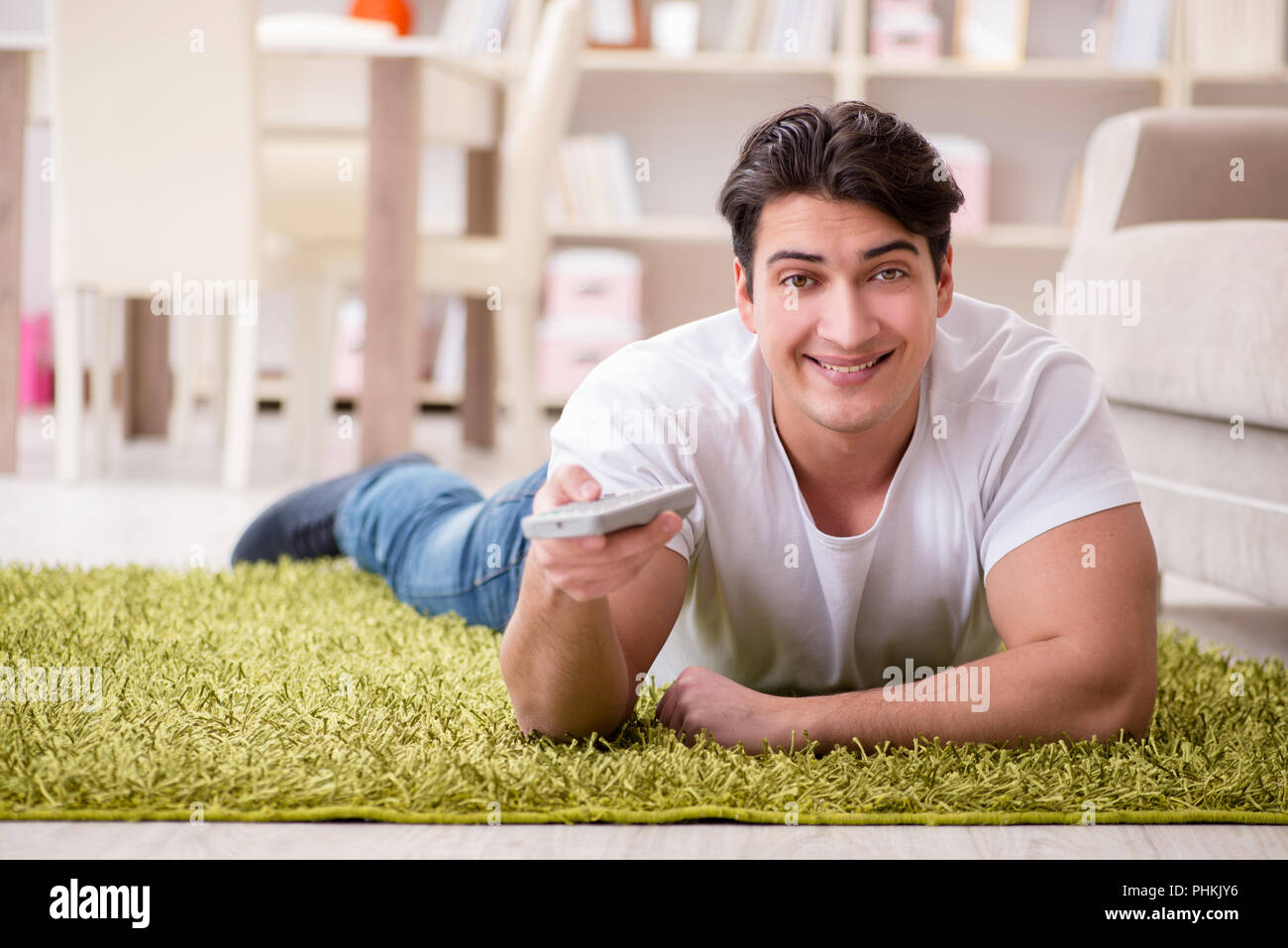 Man watching tv at home on floor Stock Photo - Alamy