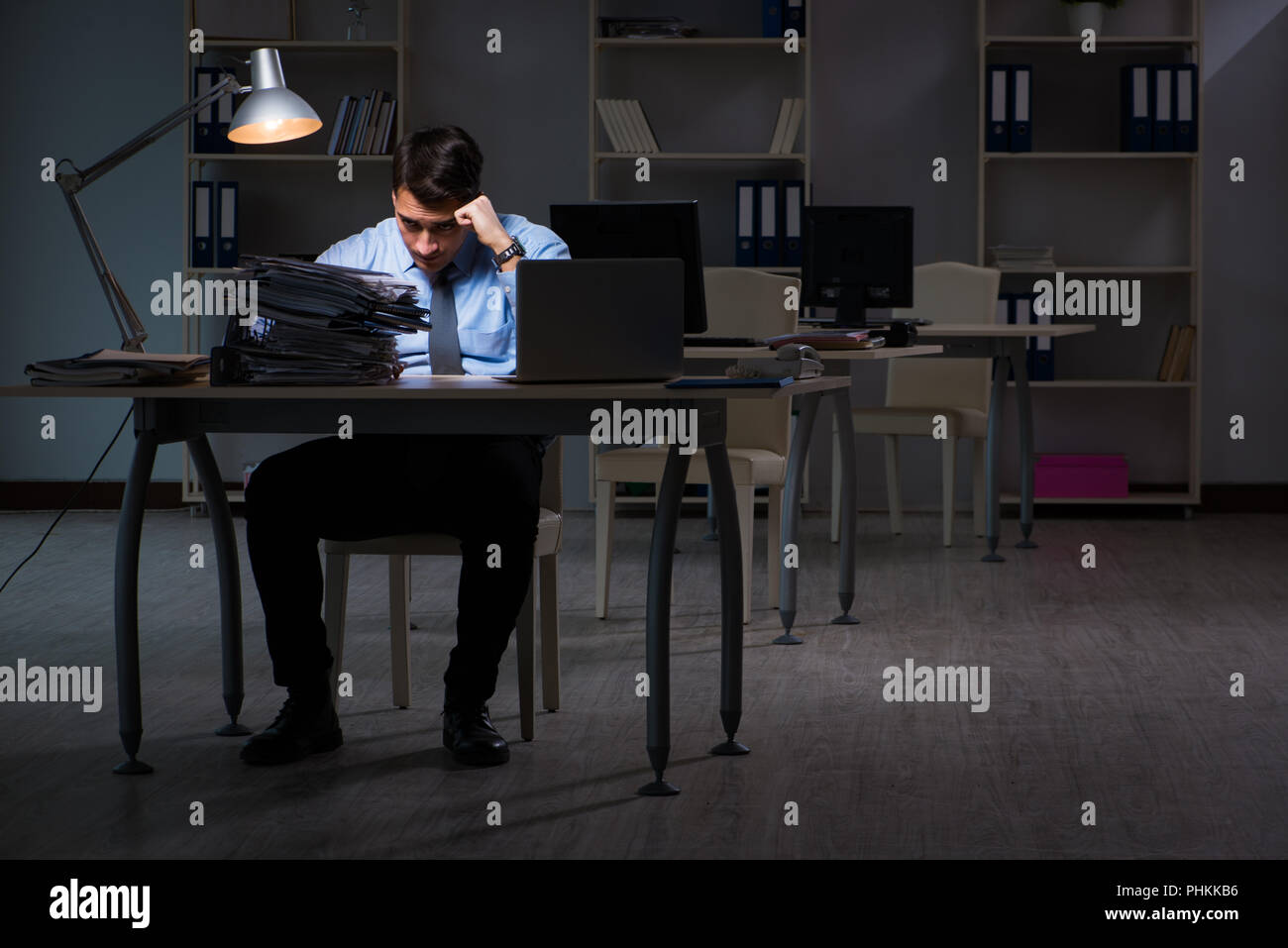 Employee working late at night at important report Stock Photo - Alamy