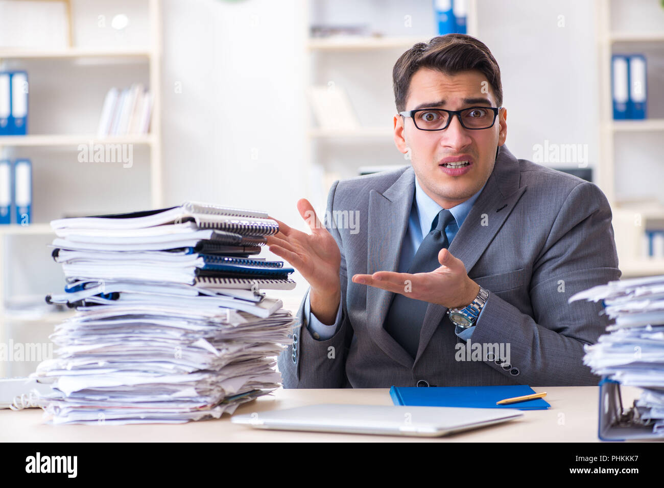 Overloaded with work employee under paperwork burden Stock Photo - Alamy