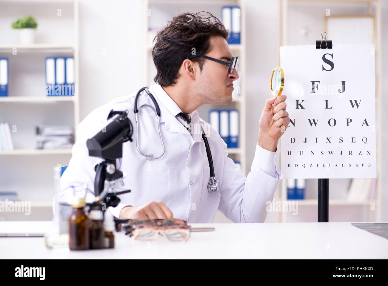 Funny eye doctor in humourous medical concept Stock Photo - Alamy