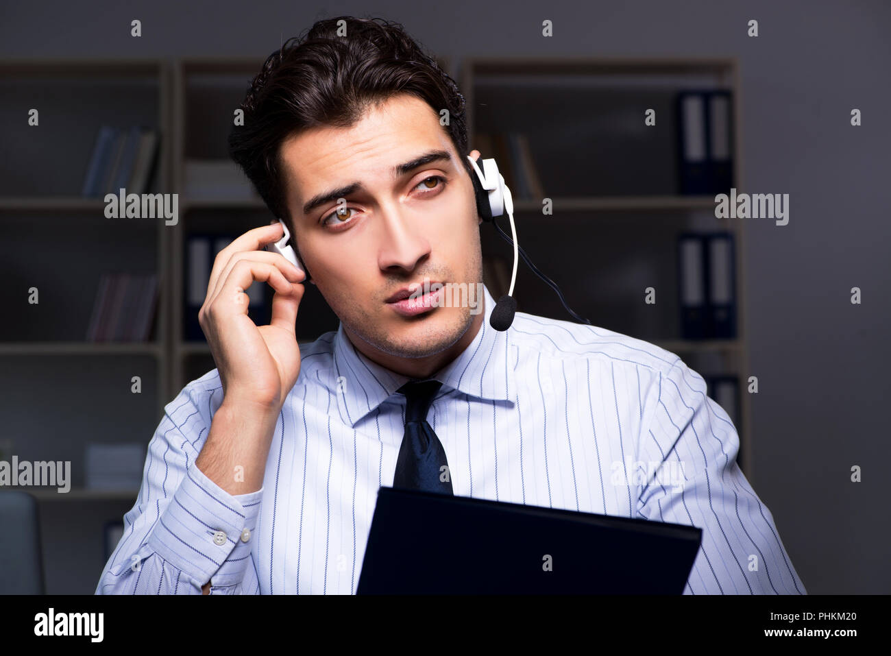 Call center operator talking to customer during night shift Stock Photo ...