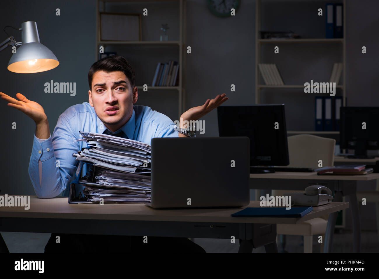 Employee working late at night at important report Stock Photo - Alamy