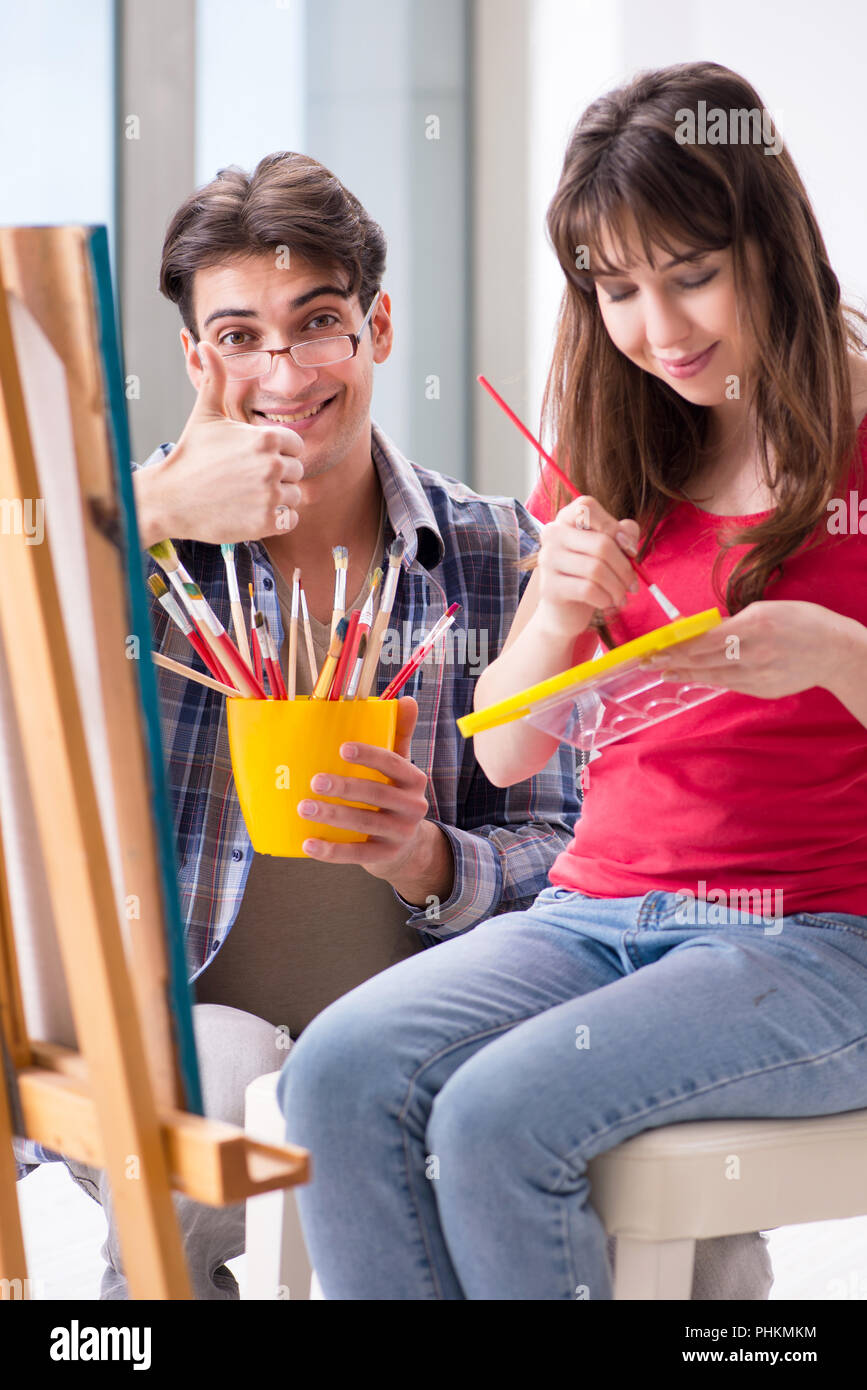 Artist coaching student in painting class in studio Stock Photo - Alamy