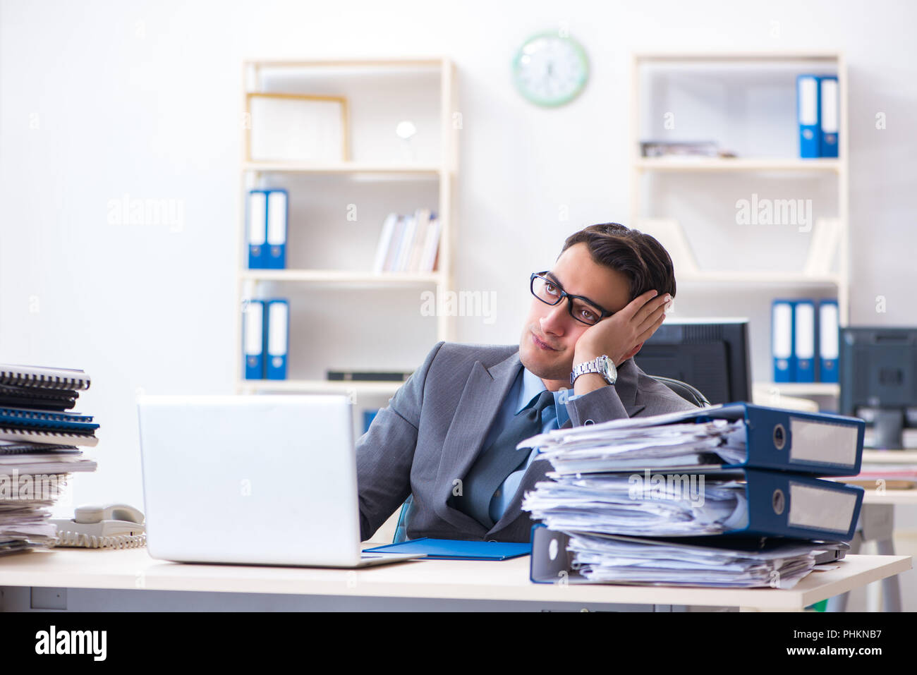 Overloaded with work employee under paperwork burden Stock Photo - Alamy