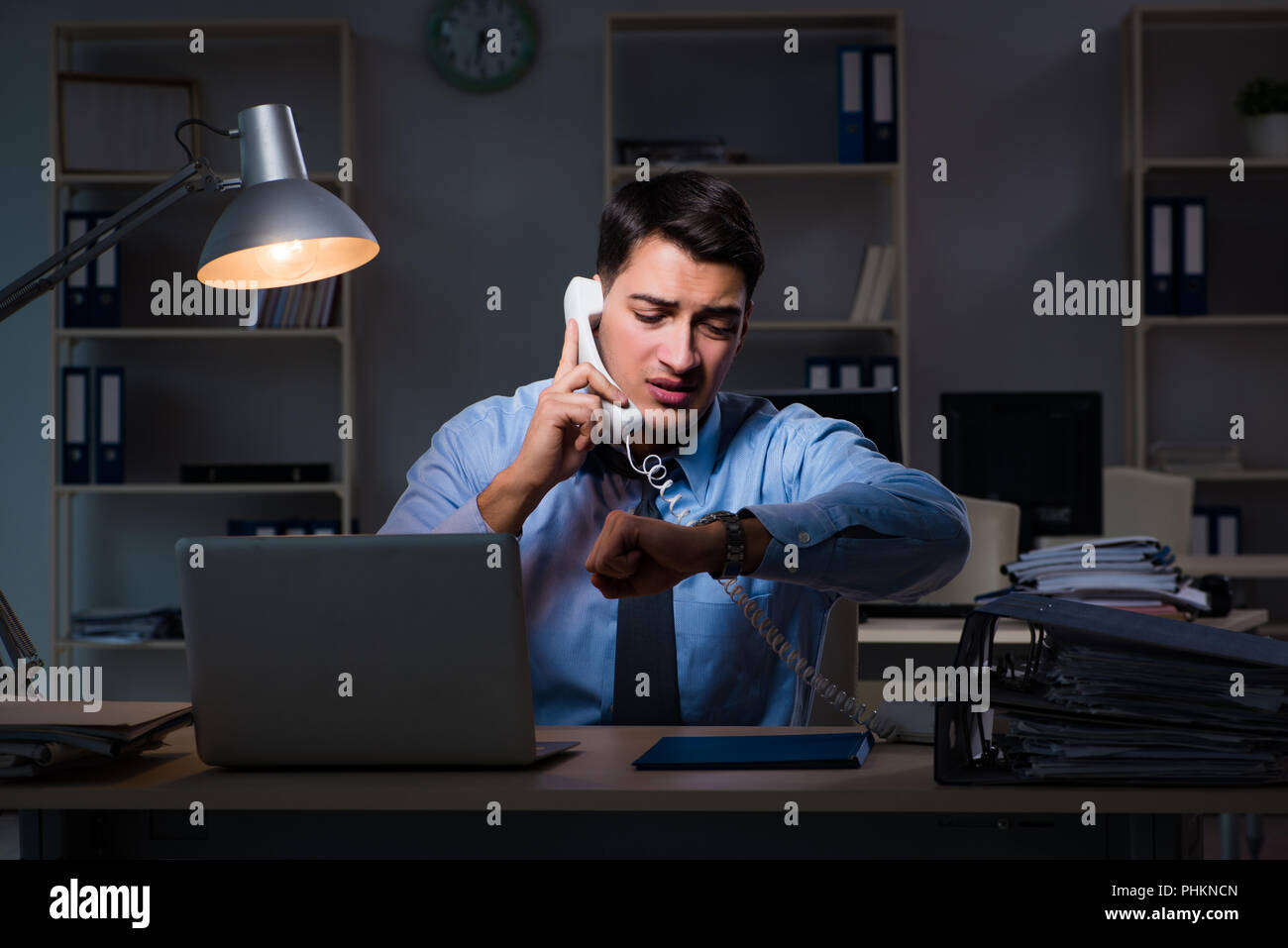 Employee working late at night at important report Stock Photo - Alamy