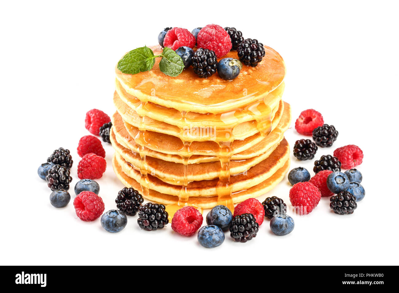 Pancakes stack with different berries and honey isolated on white ...