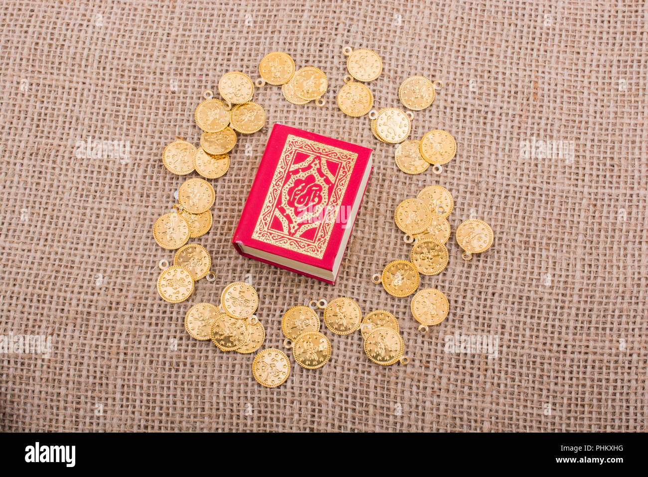 Fake gold coins around the Islamic Holy Book Quran Stock Photo - Alamy