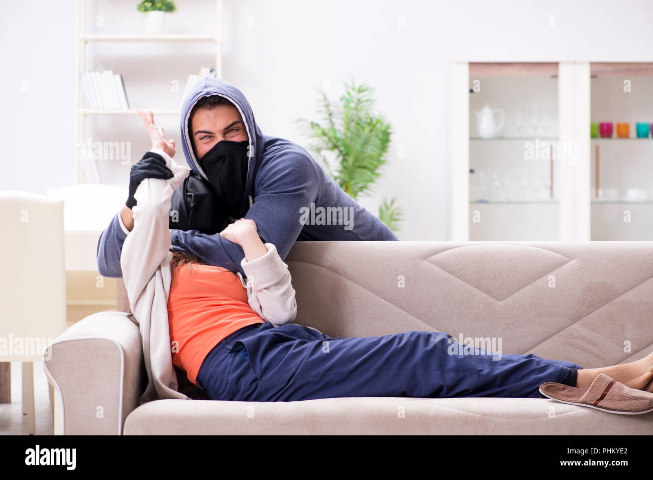 Armed man assaulting young woman at home Stock Photo - Alamy