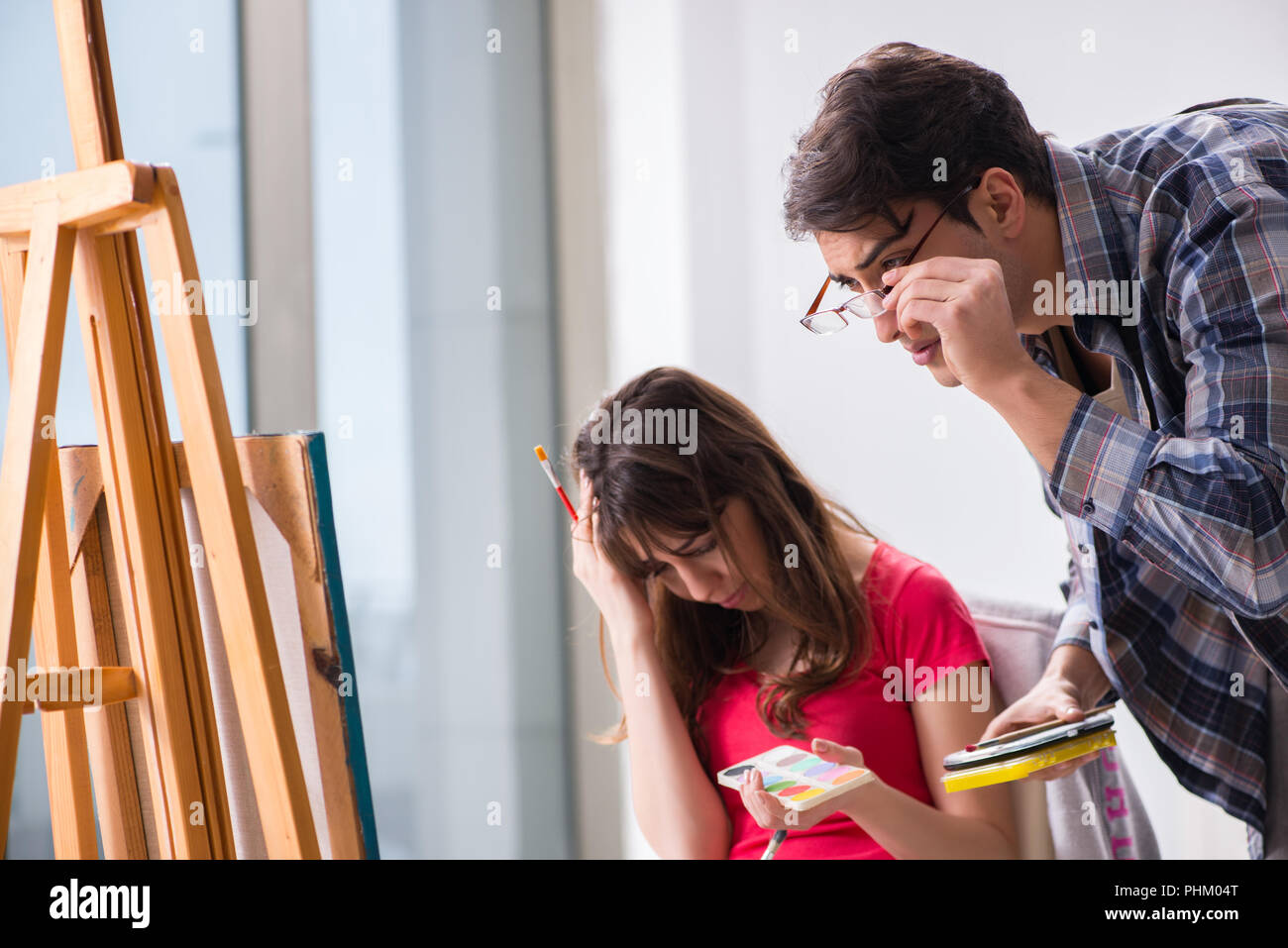 Artist coaching student in painting class in studio Stock Photo - Alamy