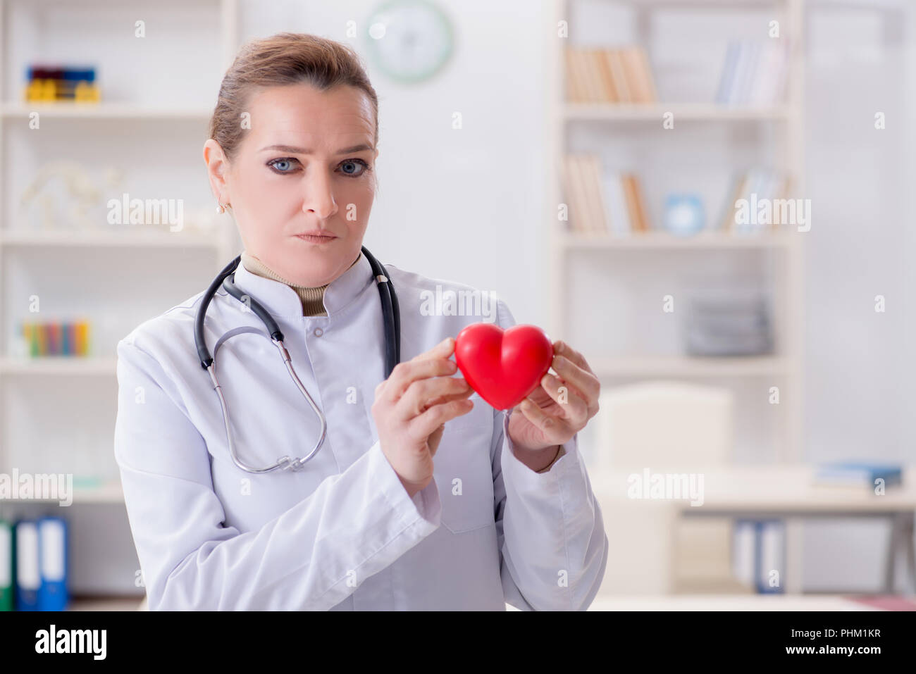 Cardiologist with red heart in medical concept Stock Photo - Alamy