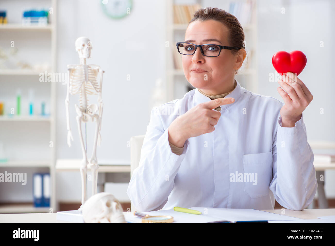 Cardiologist with red heart in medical concept Stock Photo - Alamy