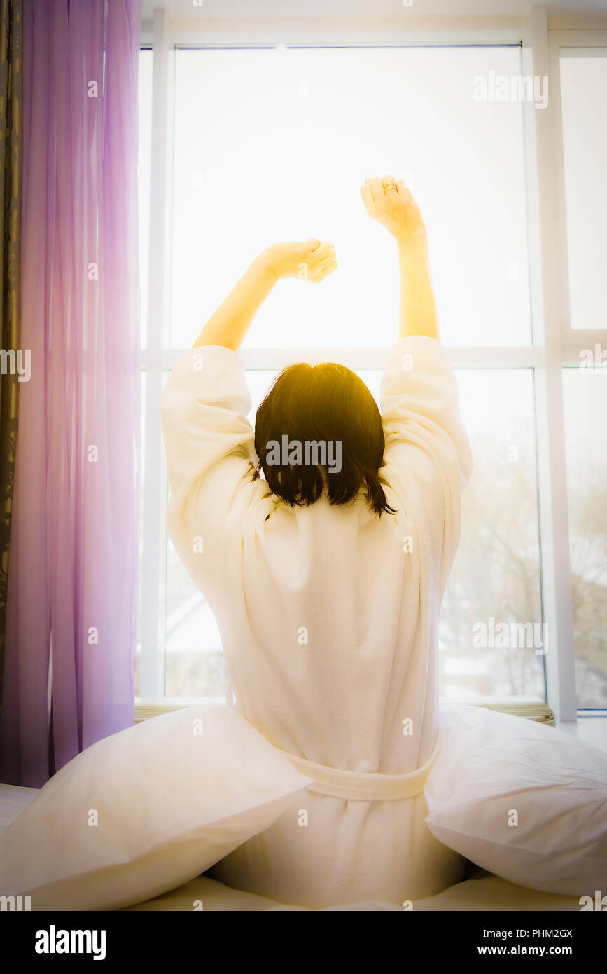 the woman is stretched out in bed Stock Photo - Alamy