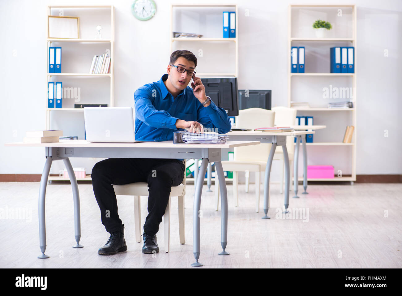 Handsome businessman employee sitting at his desk in office Stock Photo ...