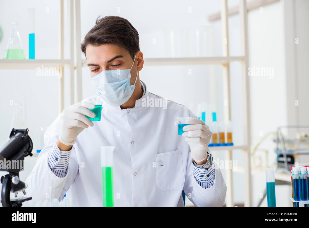 Young chemist student working in lab on chemicals Stock Photo - Alamy