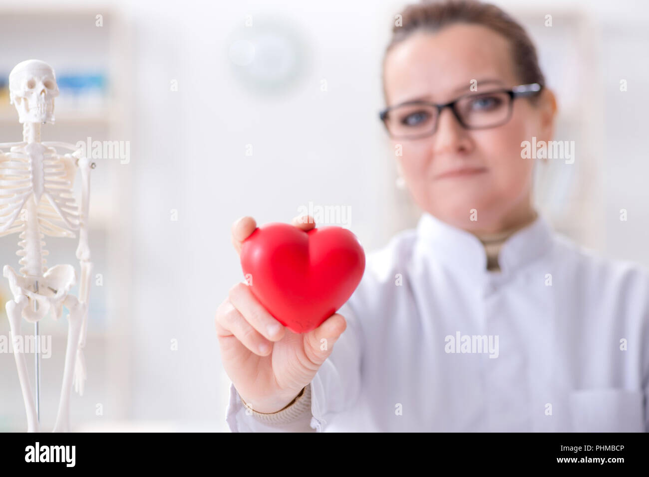Cardiologist with red heart in medical concept Stock Photo - Alamy
