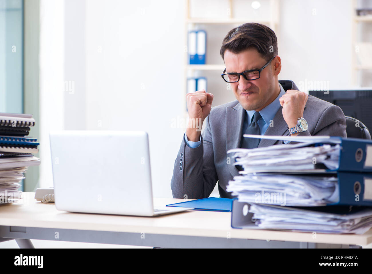 Overloaded with work employee under paperwork burden Stock Photo - Alamy