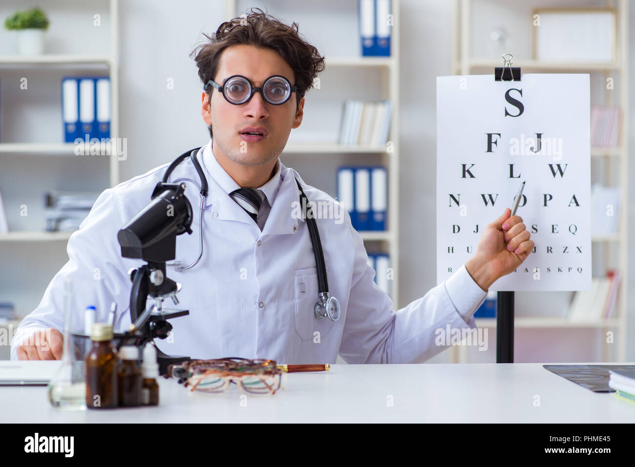 Funny eye doctor in humourous medical concept Stock Photo - Alamy