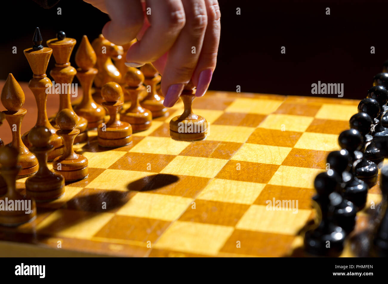 Chessboard with figures on dark background Stock Photo - Alamy