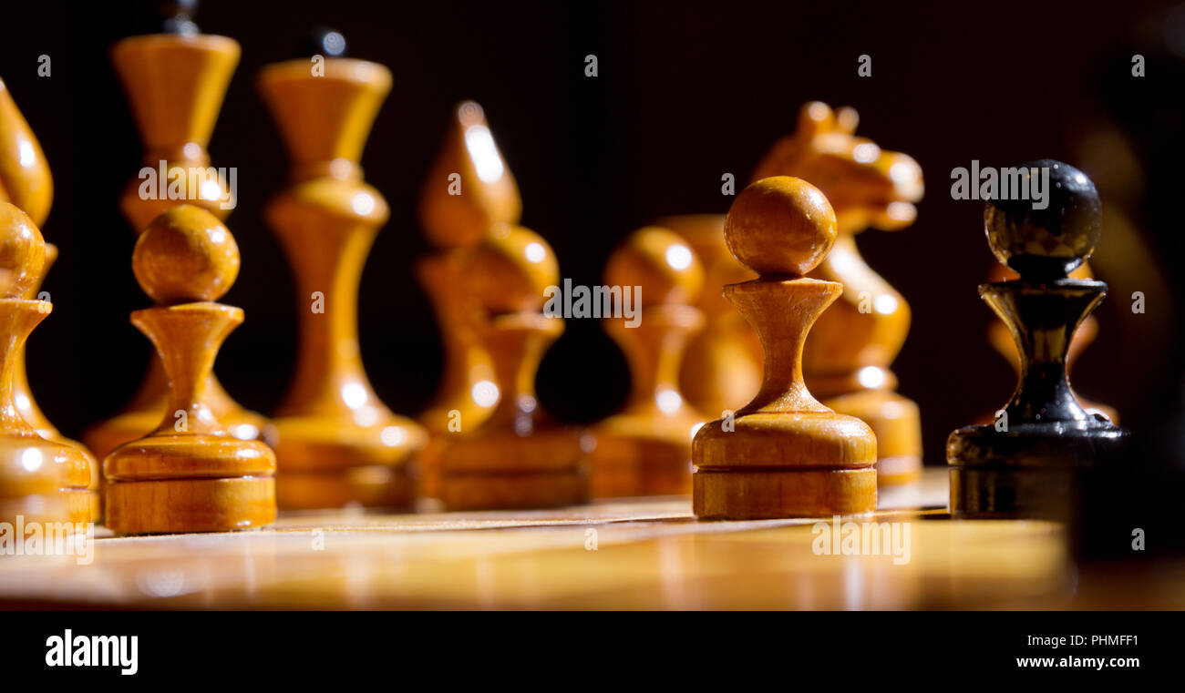 Chessboard with figures on dark background Stock Photo - Alamy