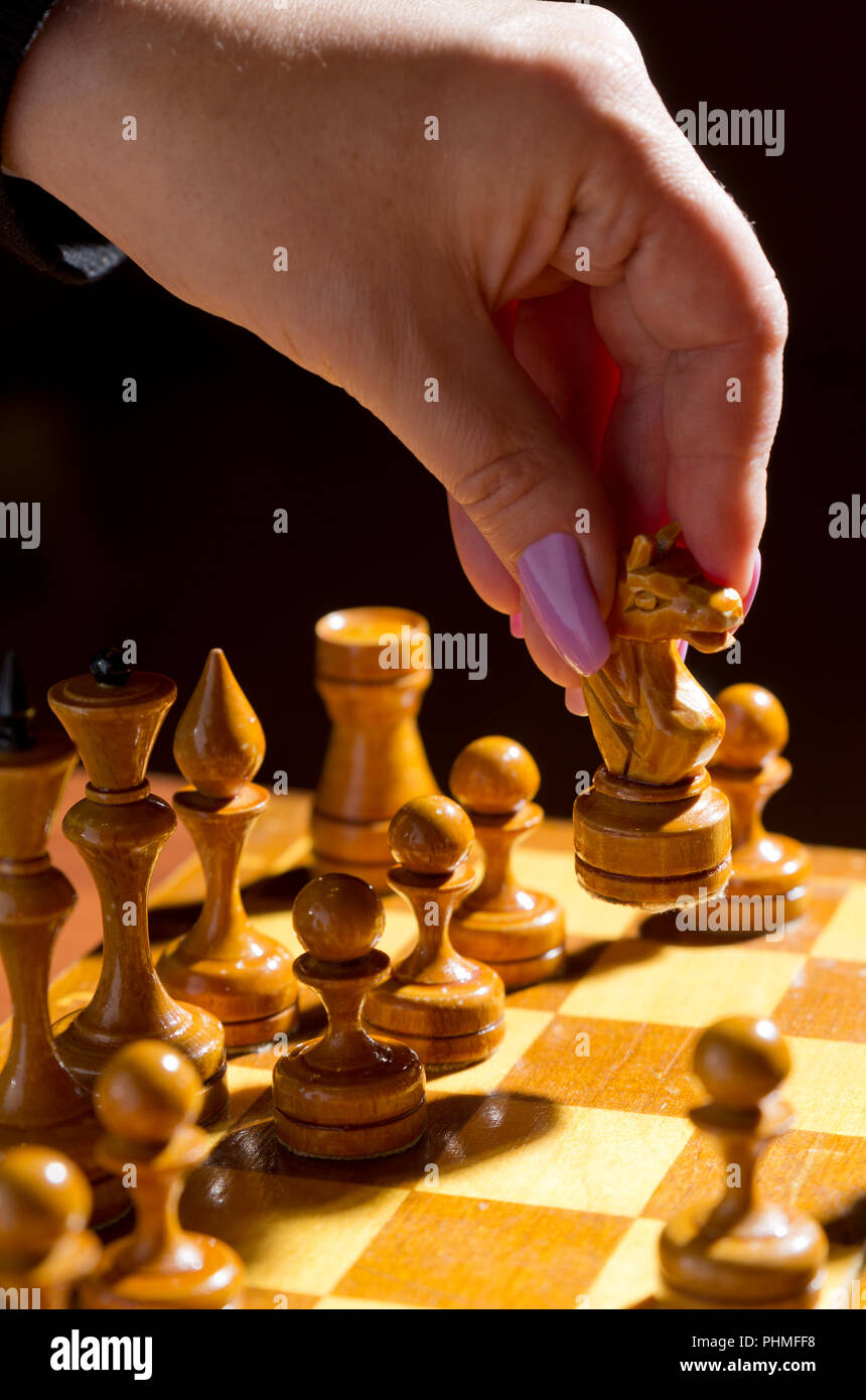 Chessboard with figures on dark background Stock Photo - Alamy