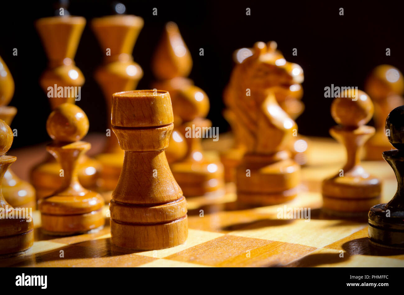 Chessboard with figures on dark background Stock Photo - Alamy