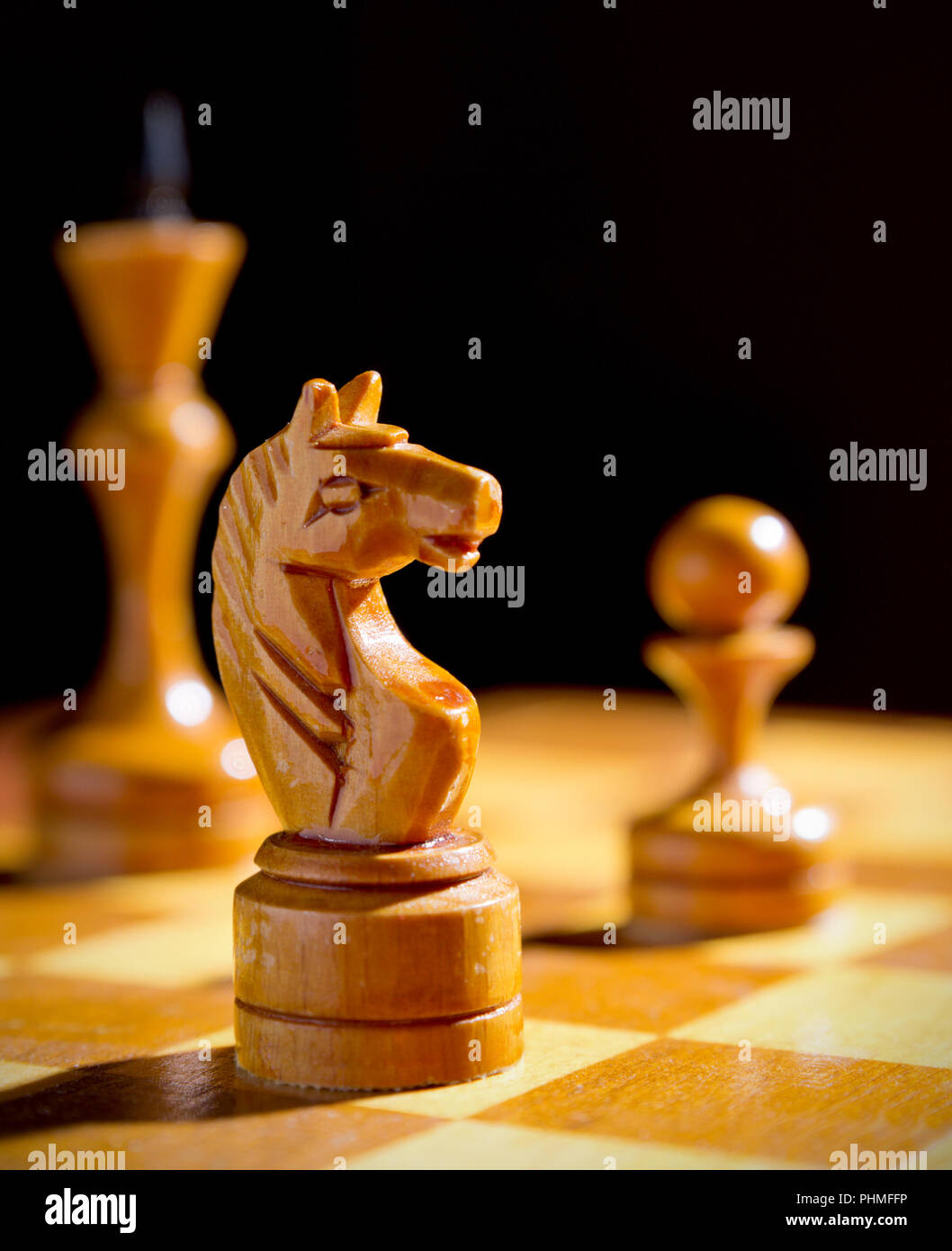 Chessboard with figures on dark background Stock Photo - Alamy