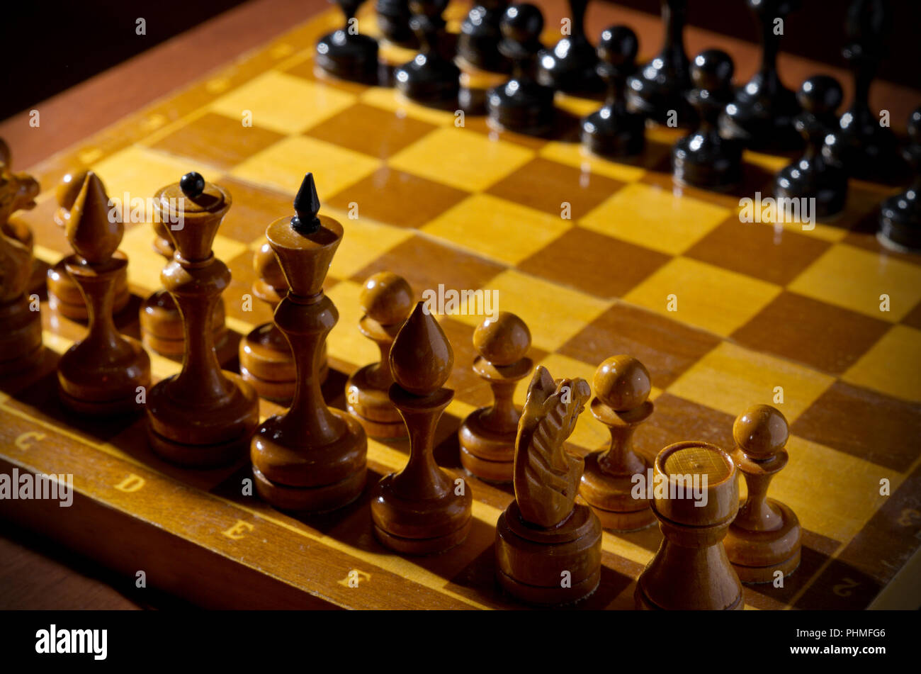 Chessboard with figures on dark background Stock Photo - Alamy