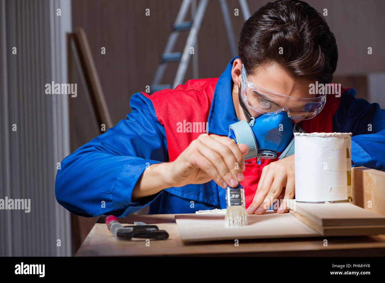Young man gluing wood pieces together in DIY concept Stock Photo - Alamy