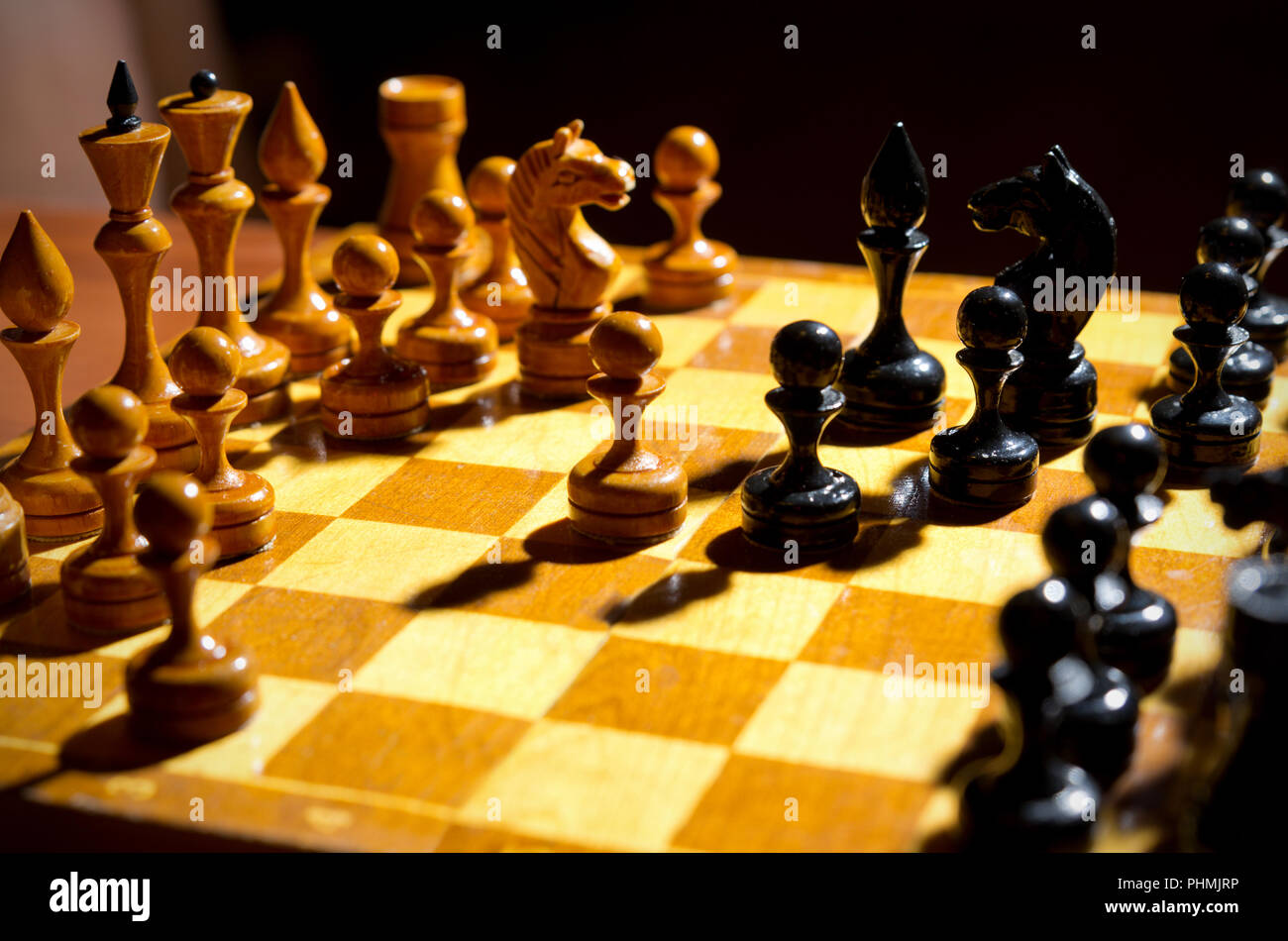 Chessboard with figures on dark background Stock Photo - Alamy