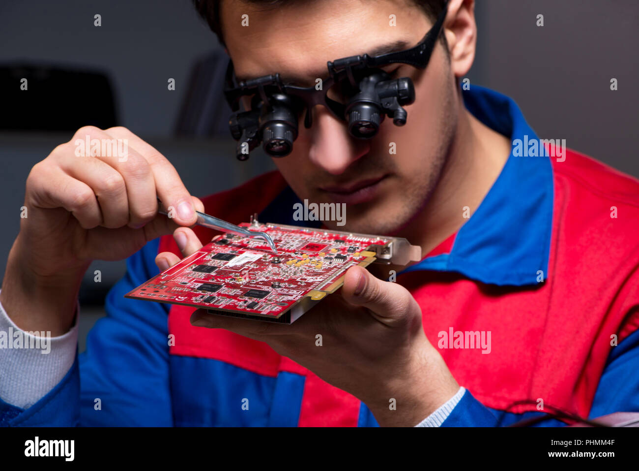Computer specialist repairing PC late at night Stock Photo - Alamy