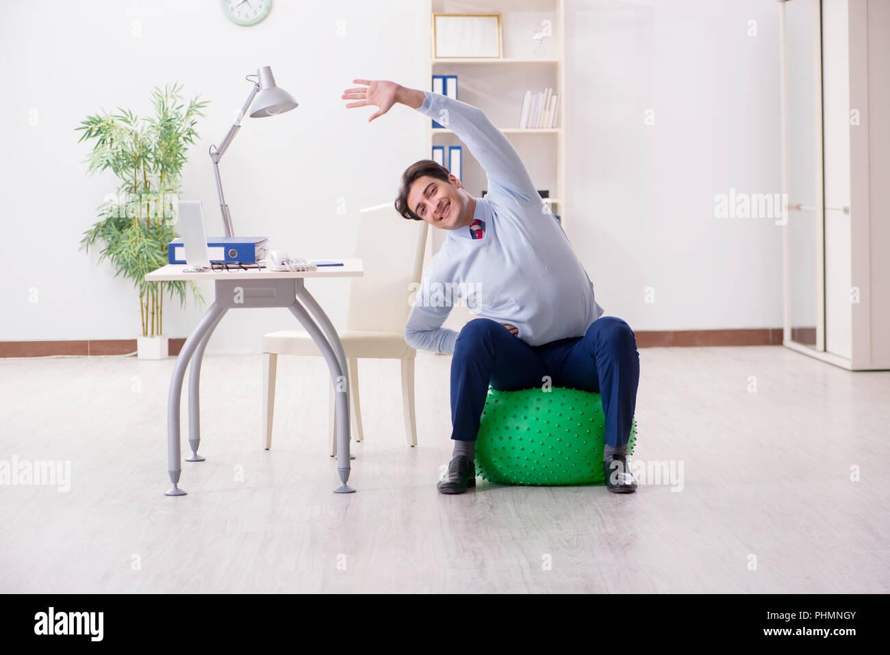 Employee exercising with swiss ball during lunch break Stock Photo - Alamy