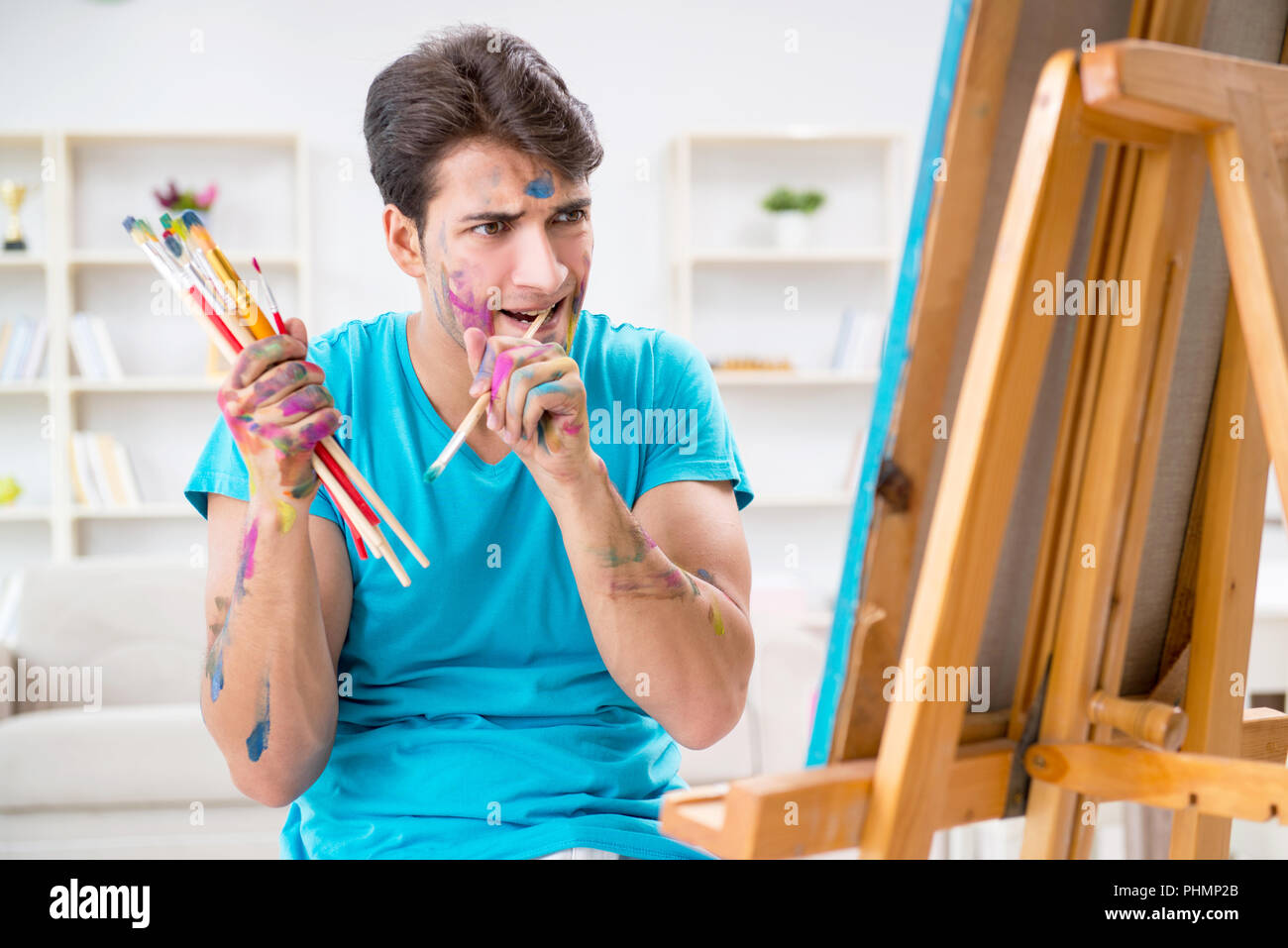 Young funny artist working on new painting in his studio Stock Photo ...