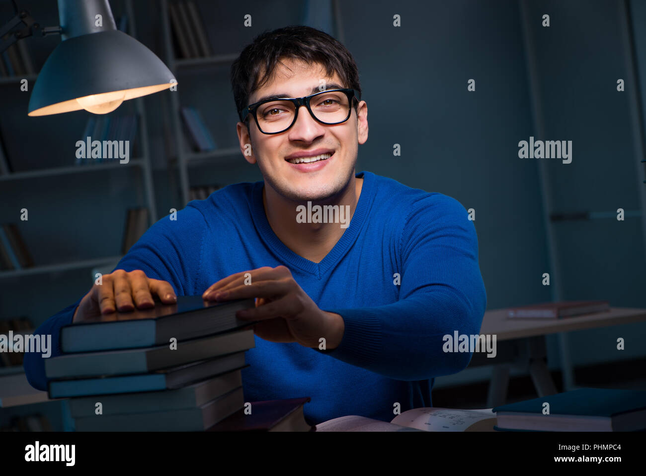 Student preparing for exams late at night in library Stock Photo - Alamy