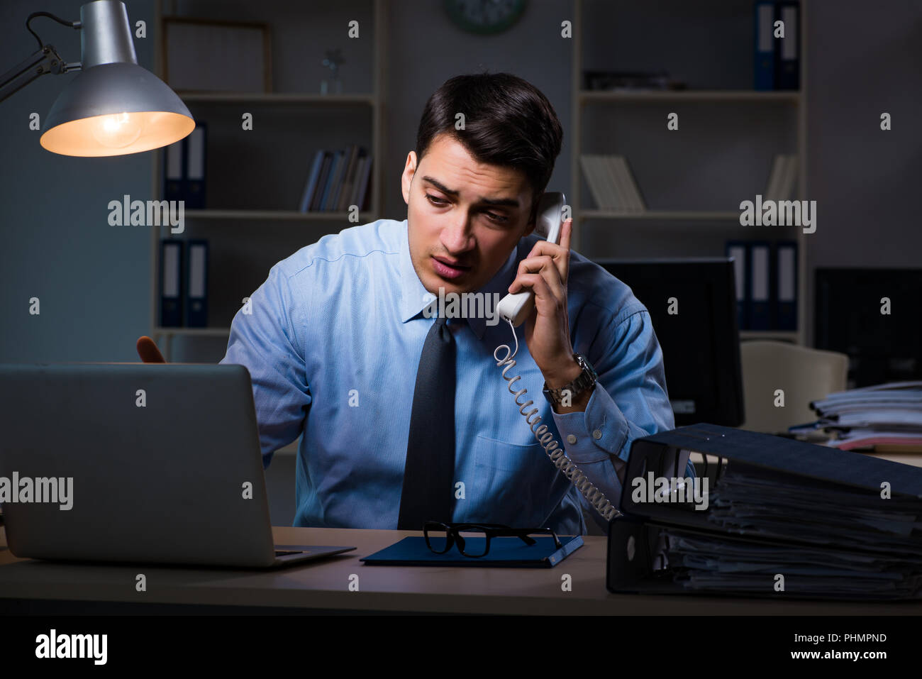 Employee working late at night at important report Stock Photo - Alamy