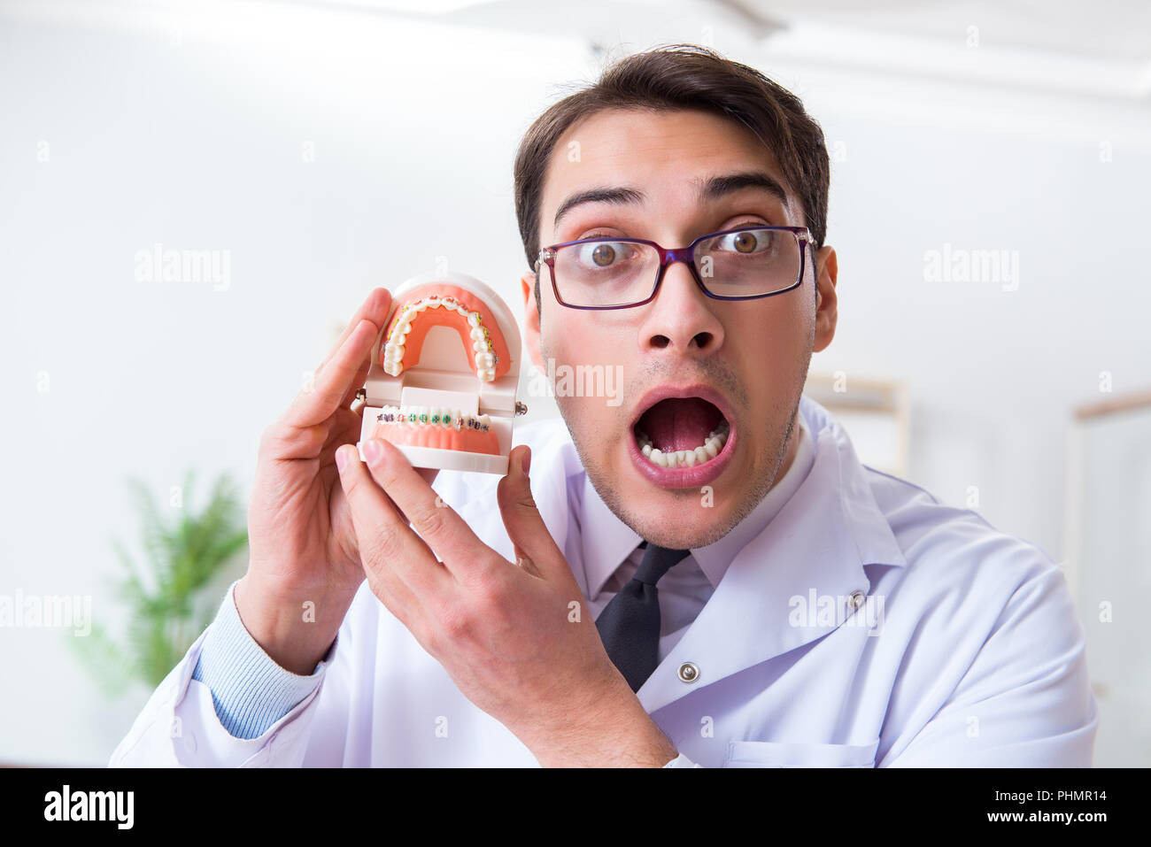 Funny dentist with teeth model in hospital Stock Photo - Alamy
