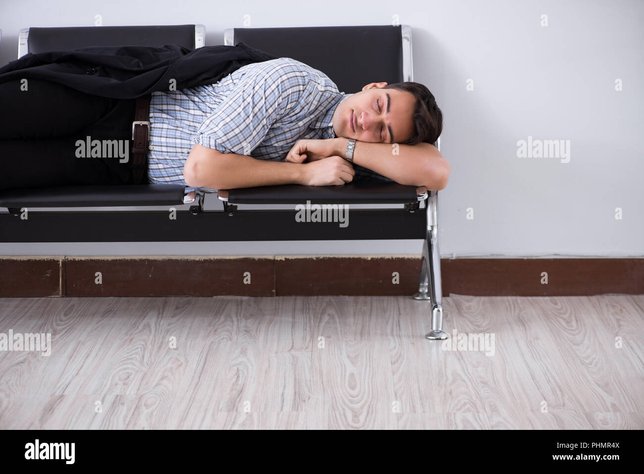 Man sleeping on the chairs in airport Stock Photo - Alamy