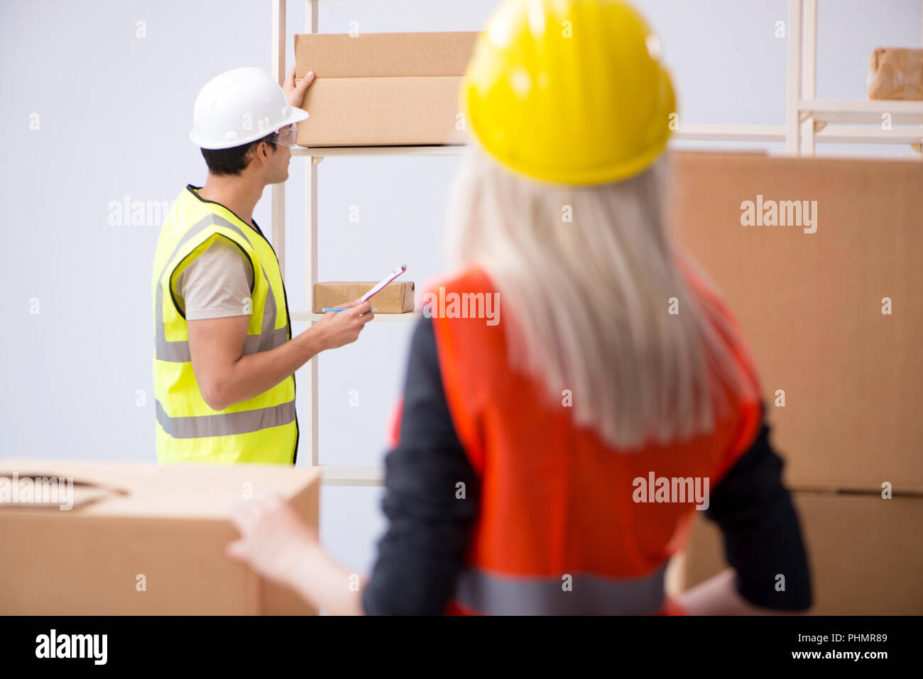 Delivery contractor delivering boxes to office Stock Photo - Alamy