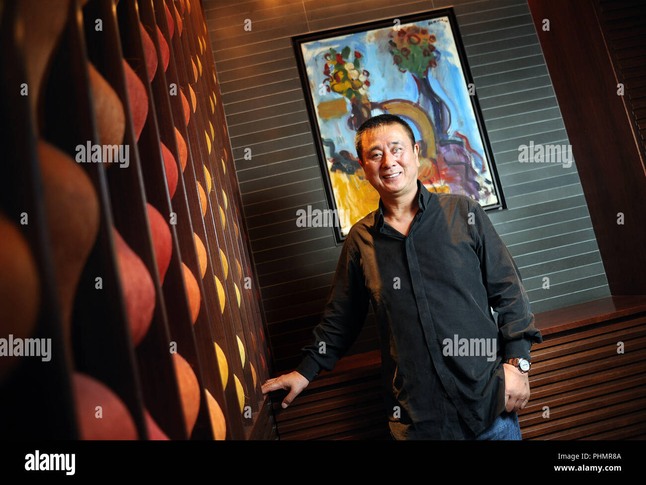 Chef Nobu Matsuhisa poses in front of a painting by the father of his ...