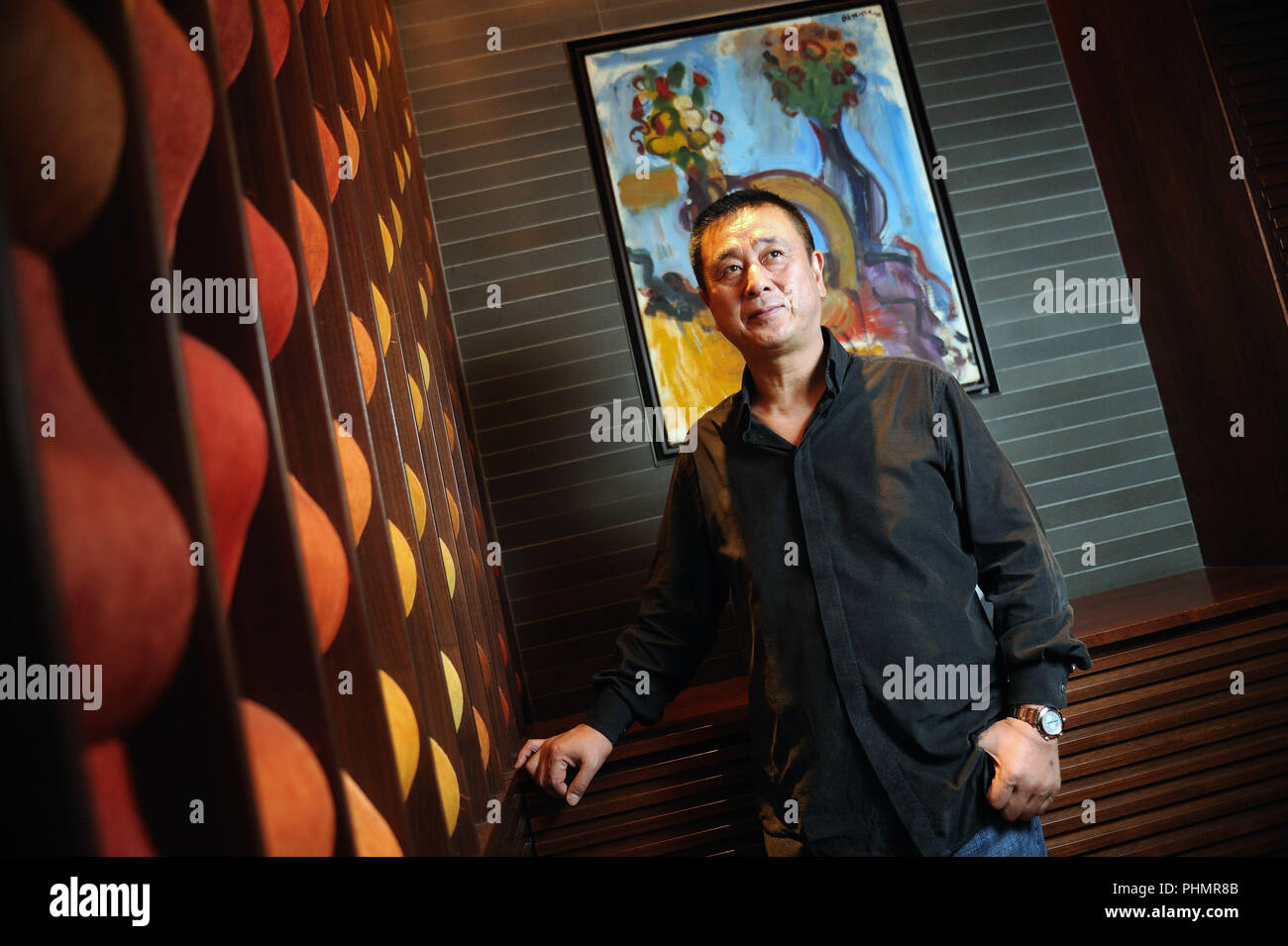 Chef Nobu Matsuhisa poses in front of a painting by the father of his ...
