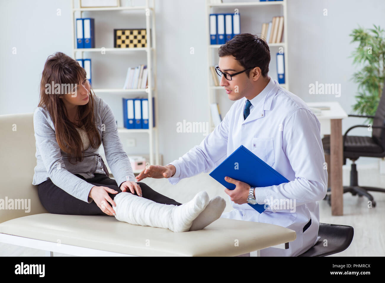 Doctor examining patient with broken leg Stock Photo - Alamy