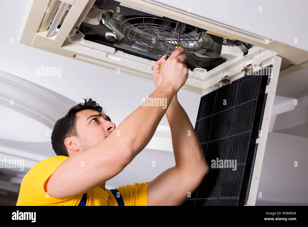 Repairman repairing ceiling air conditioning unit Stock Photo - Alamy